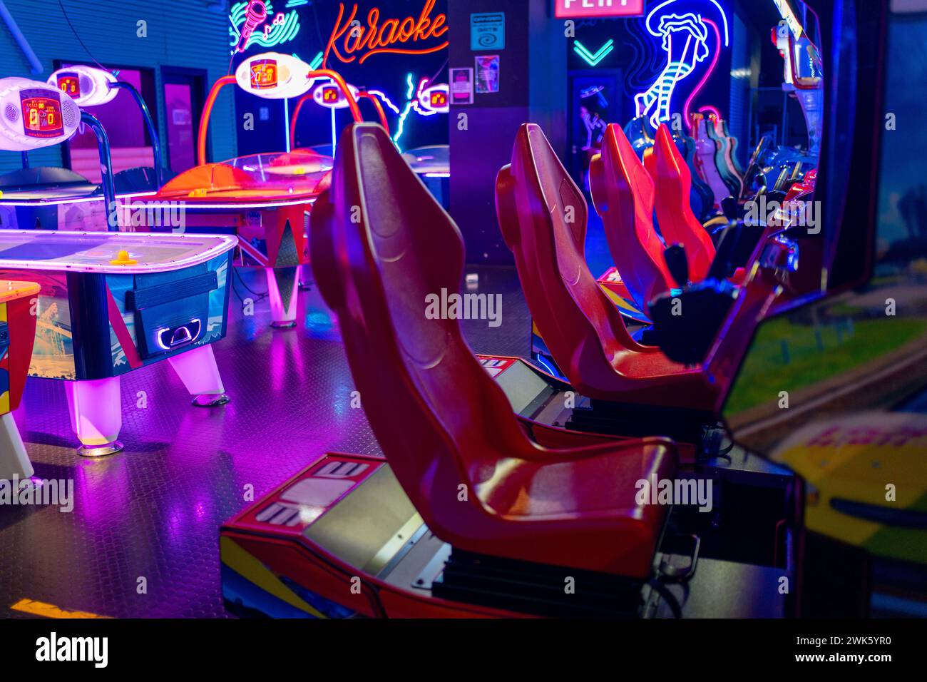 Row of racing arcade machines inside a neon-lit shopping mall ...