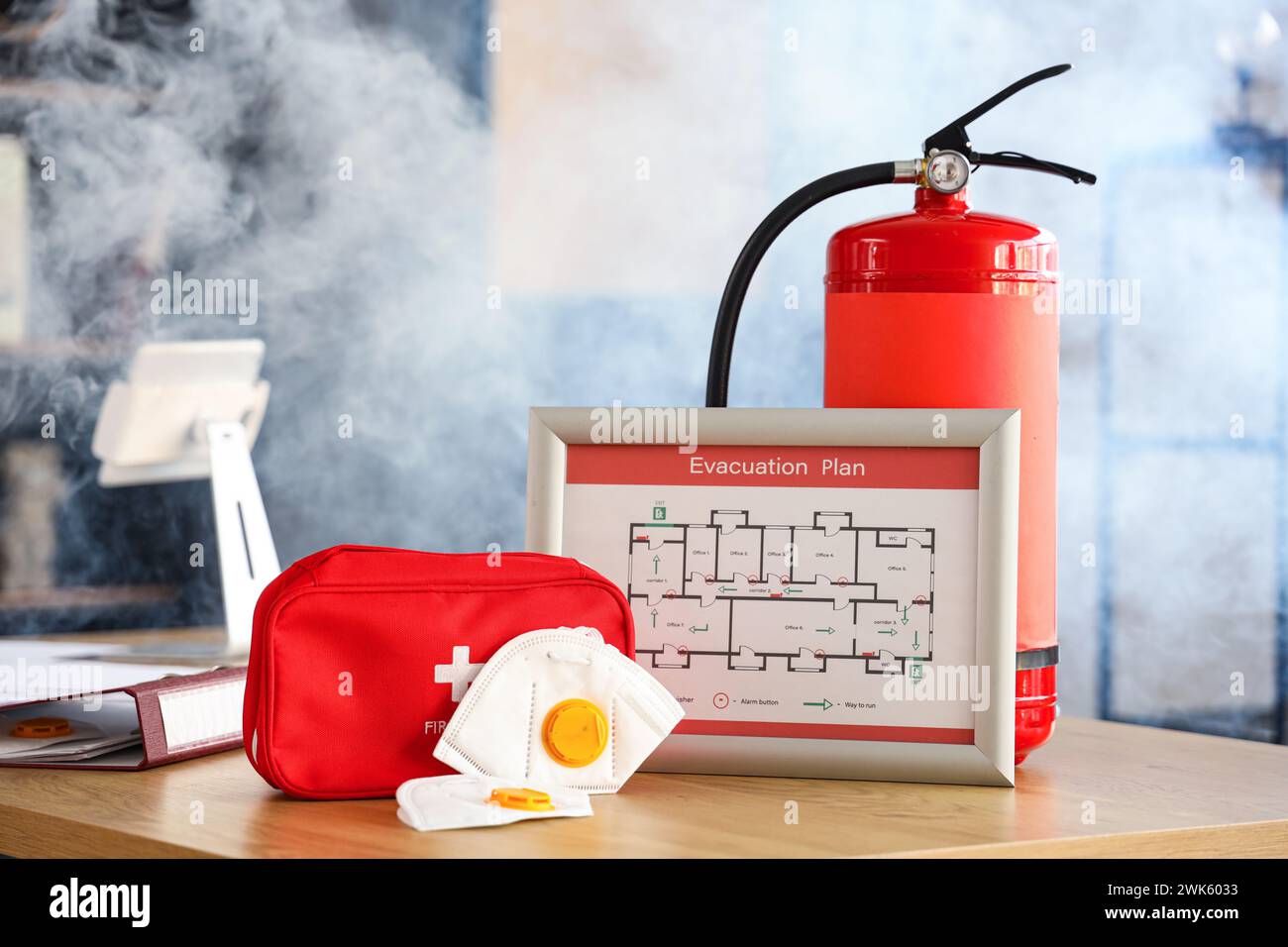 Evacuation plan with masks, first aid kit and fire extinguisher on ...