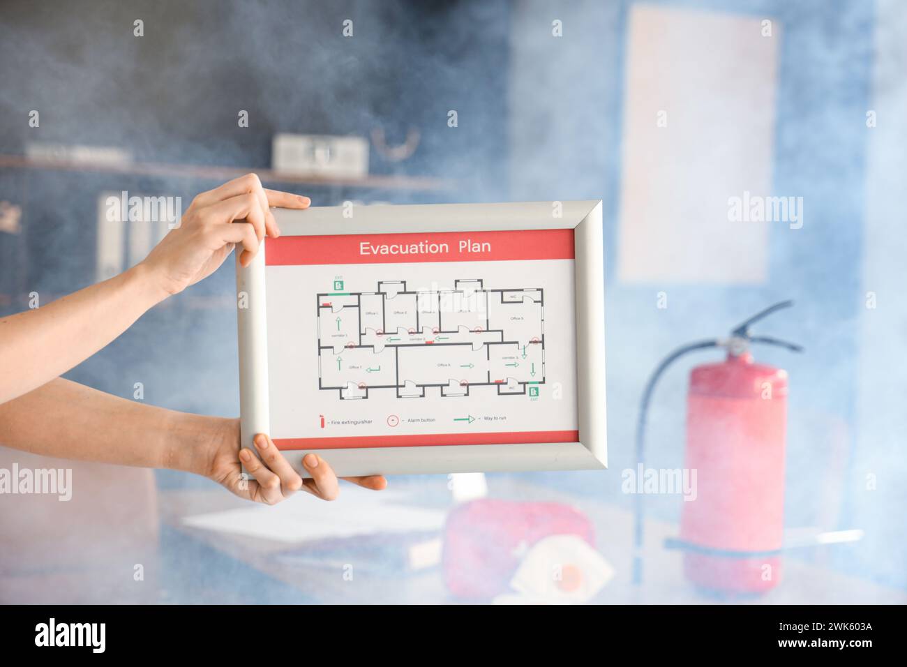 Woman with evacuation plan in burning office building, closeup Stock ...
