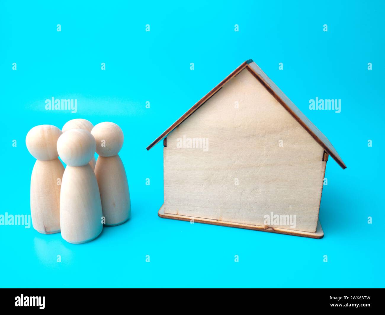 Wooden people figures and wooden house om blue background. Real estate ...