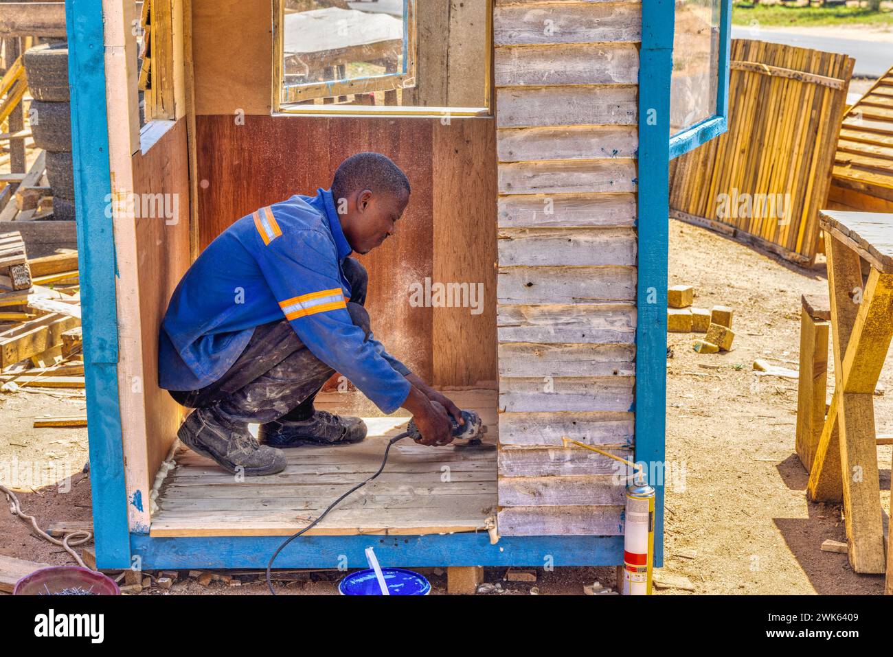 african american carpenter making a wendy house, wooden shed outdoors ...