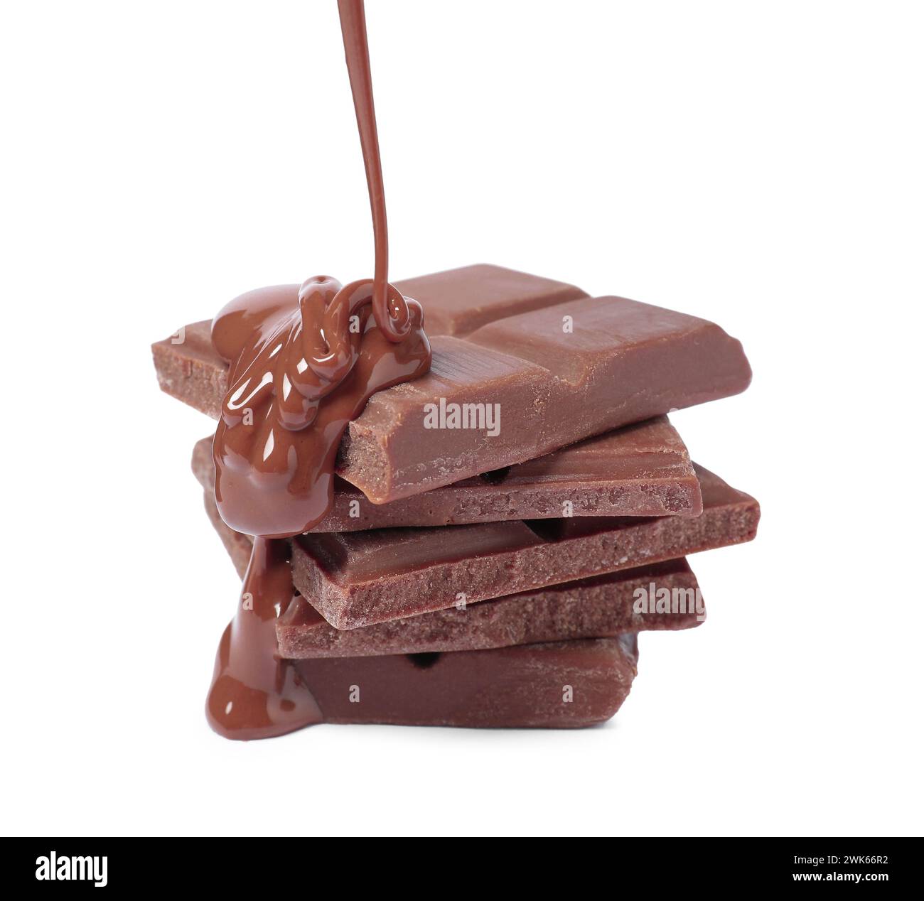 Pouring tasty milk chocolate paste onto pieces isolated on white Stock ...