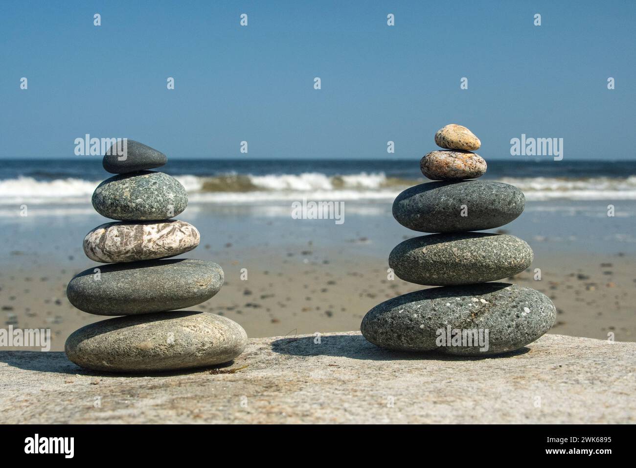 Rock cairns at the beach with waves in the distance Stock Photo - Alamy