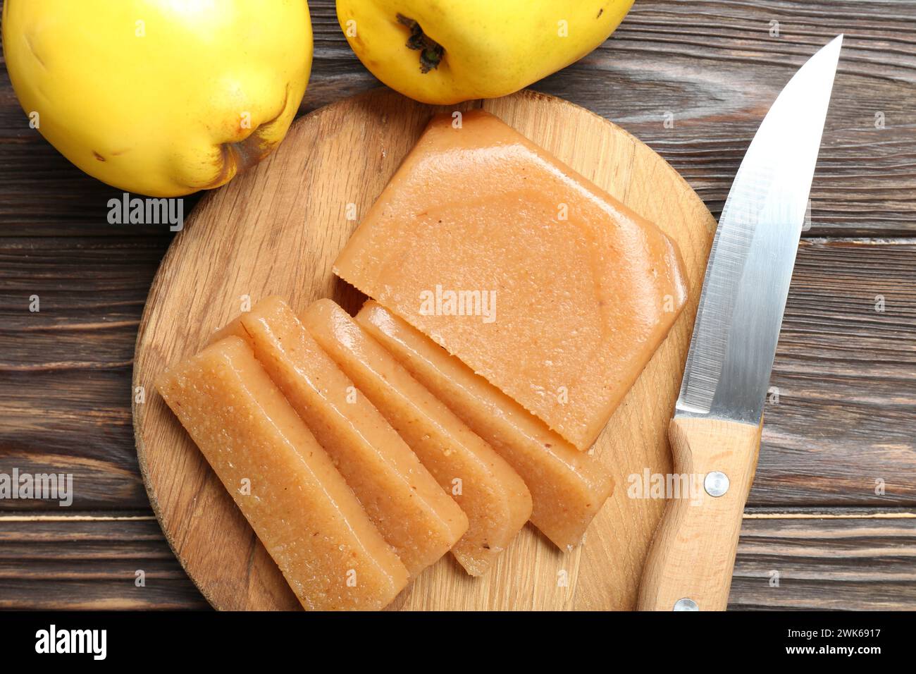 Tasty sweet quince paste, fresh fruits and knife on wooden table, flat ...