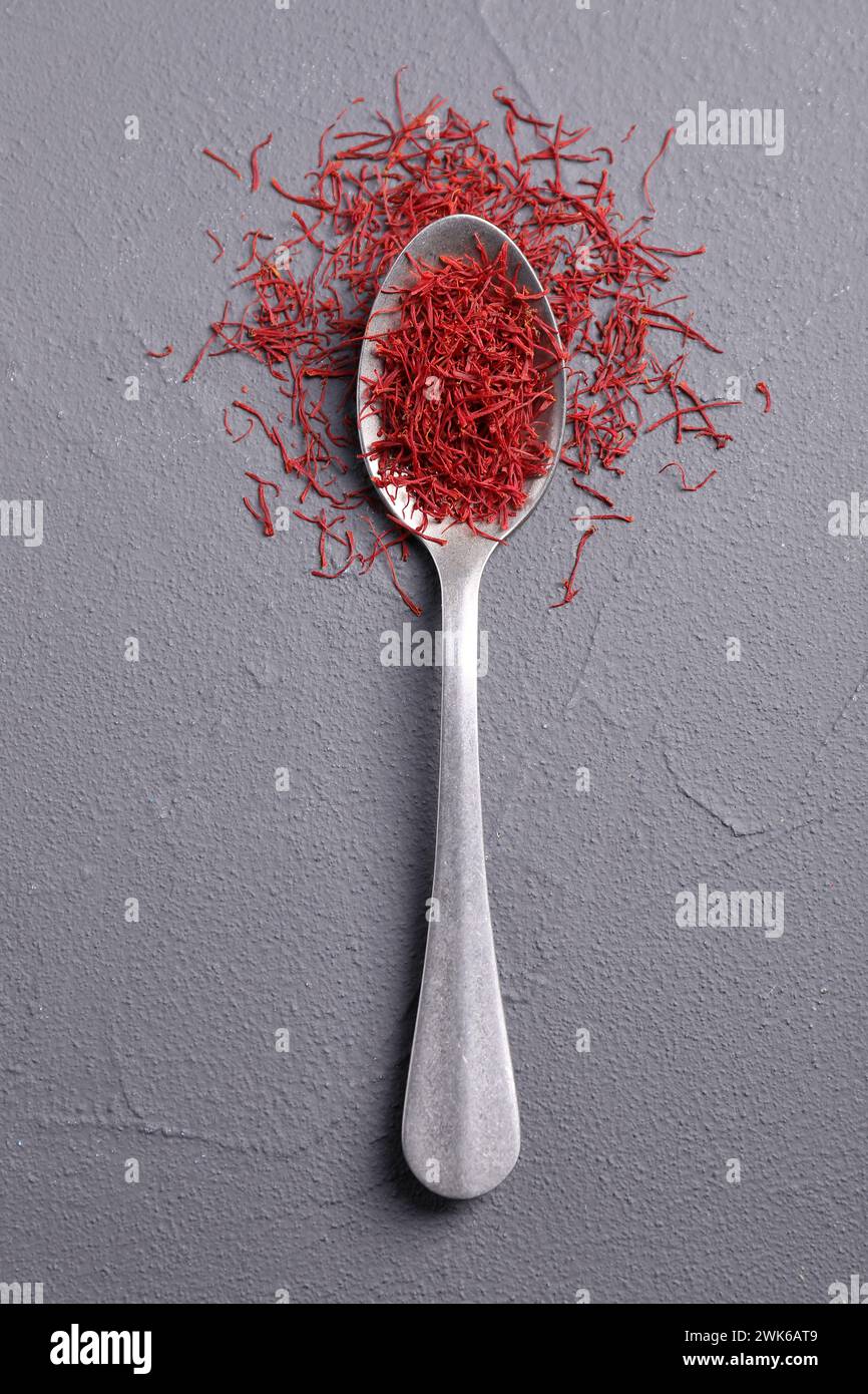 Aromatic saffron and spoon on gray table, top view Stock Photo - Alamy