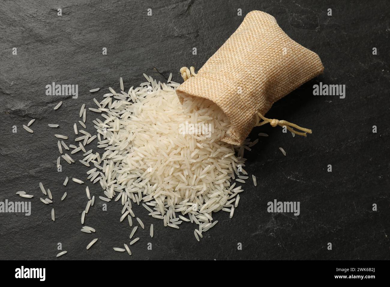 Raw basmati rice and overturned sack on black table, top view Stock ...