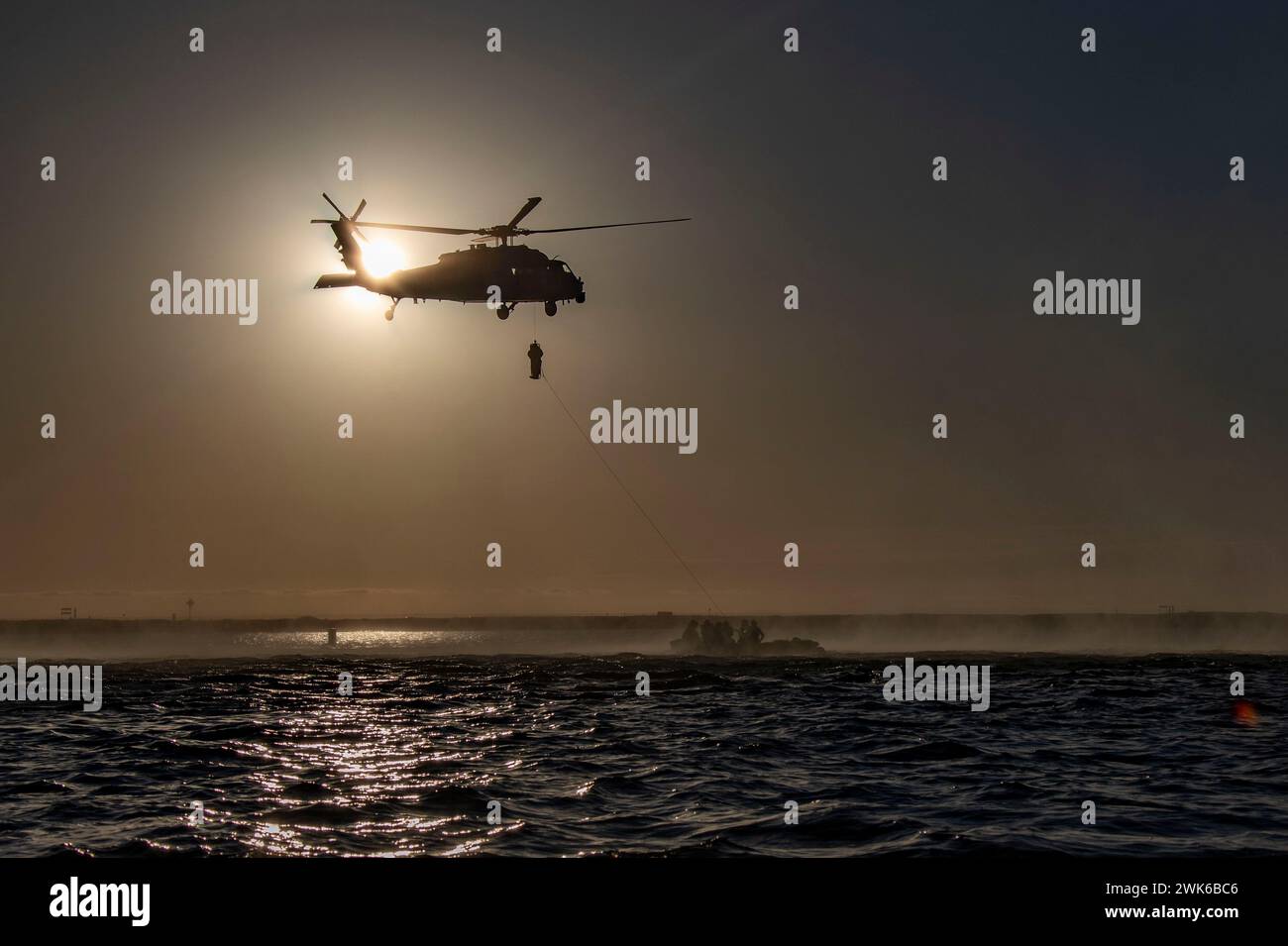 An MH-60S Seahawk lifts a mock survivor on a stretcher up from a life ...