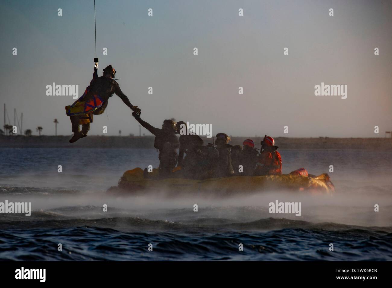 A Sailor lowers from an MH-60S Seahawk to a life raft during maritime ...