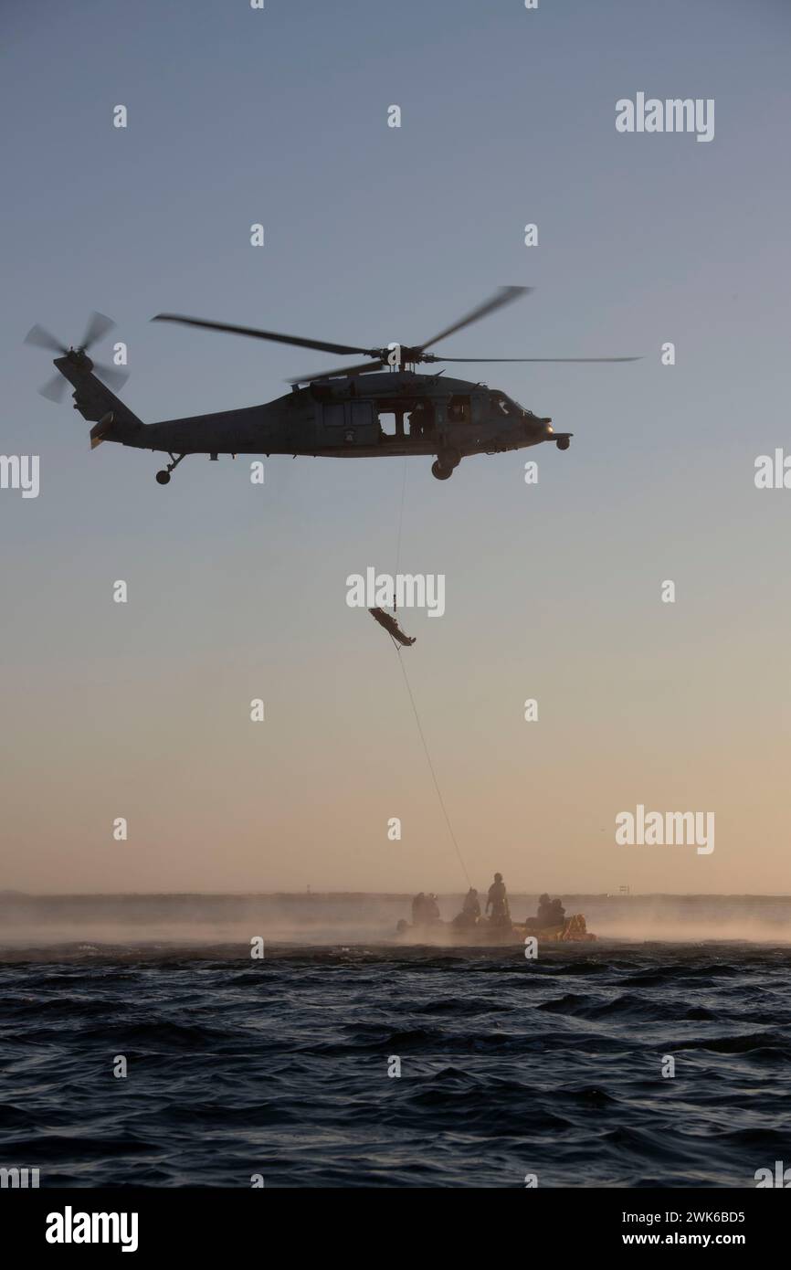 An MH-60S Seahawk lifts a mock survivor on a stretcher up from a life ...