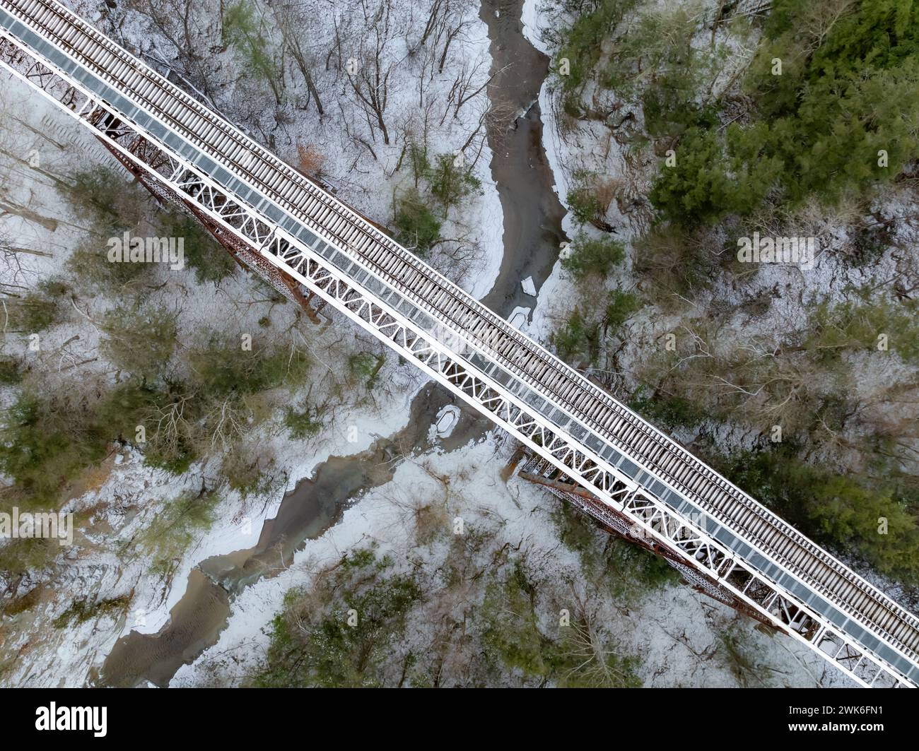Winter aerial photos of a rusty old iron railway bridge over a forest ...