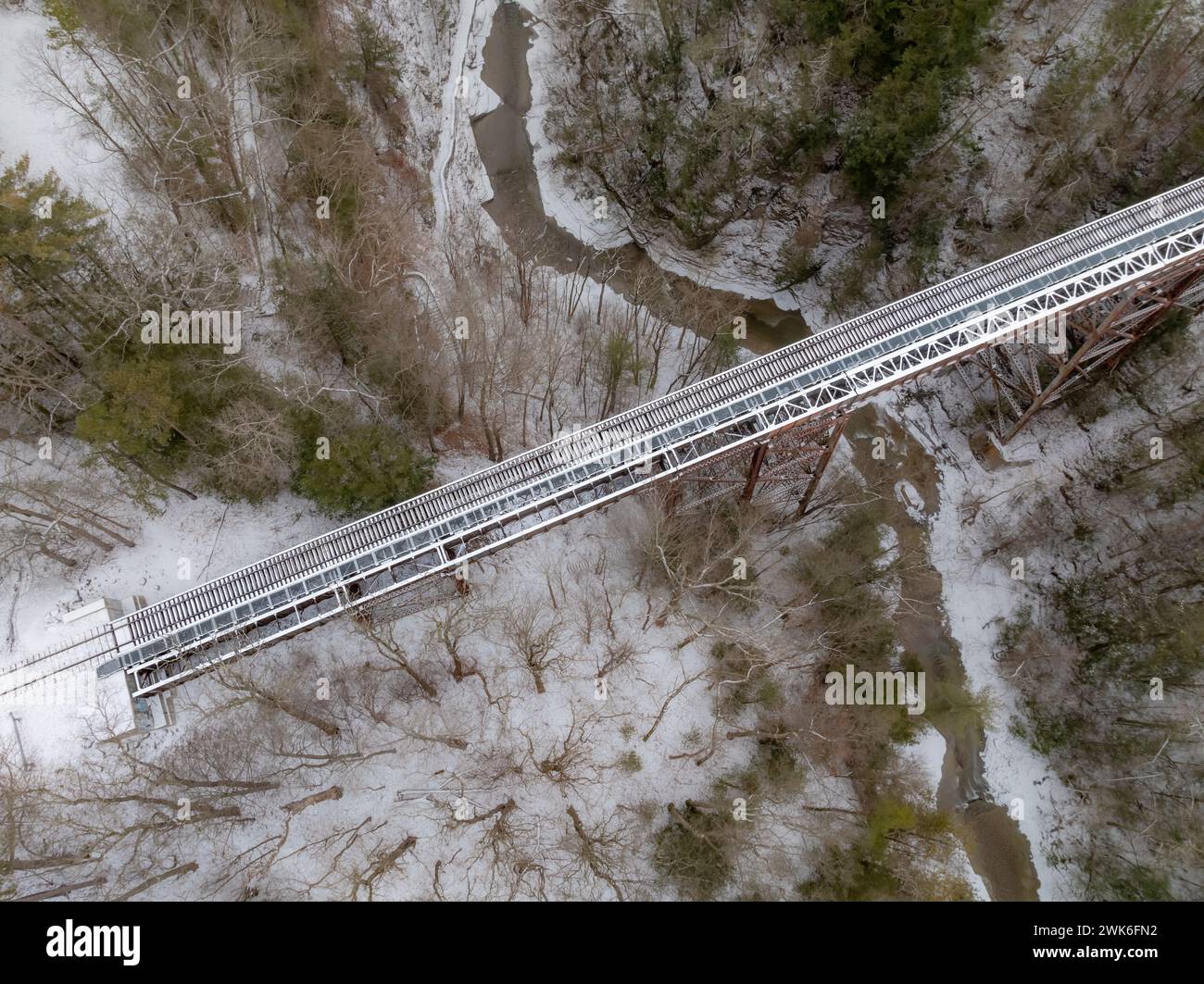 Winter aerial photos of a rusty old iron railway bridge over a forest ...