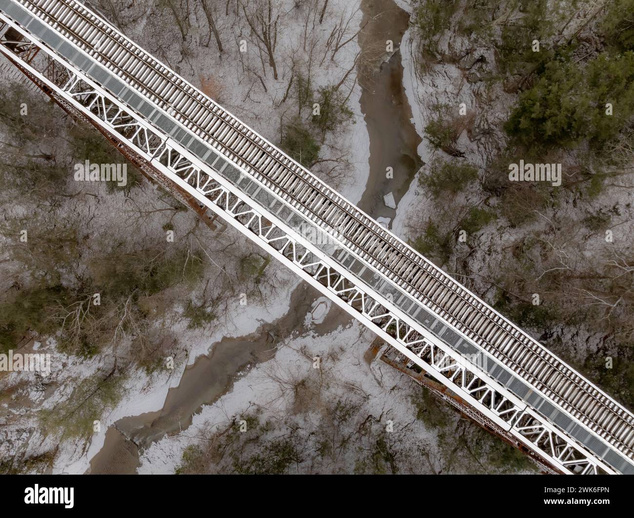 Winter aerial photos of a rusty old iron railway bridge over a forest ...