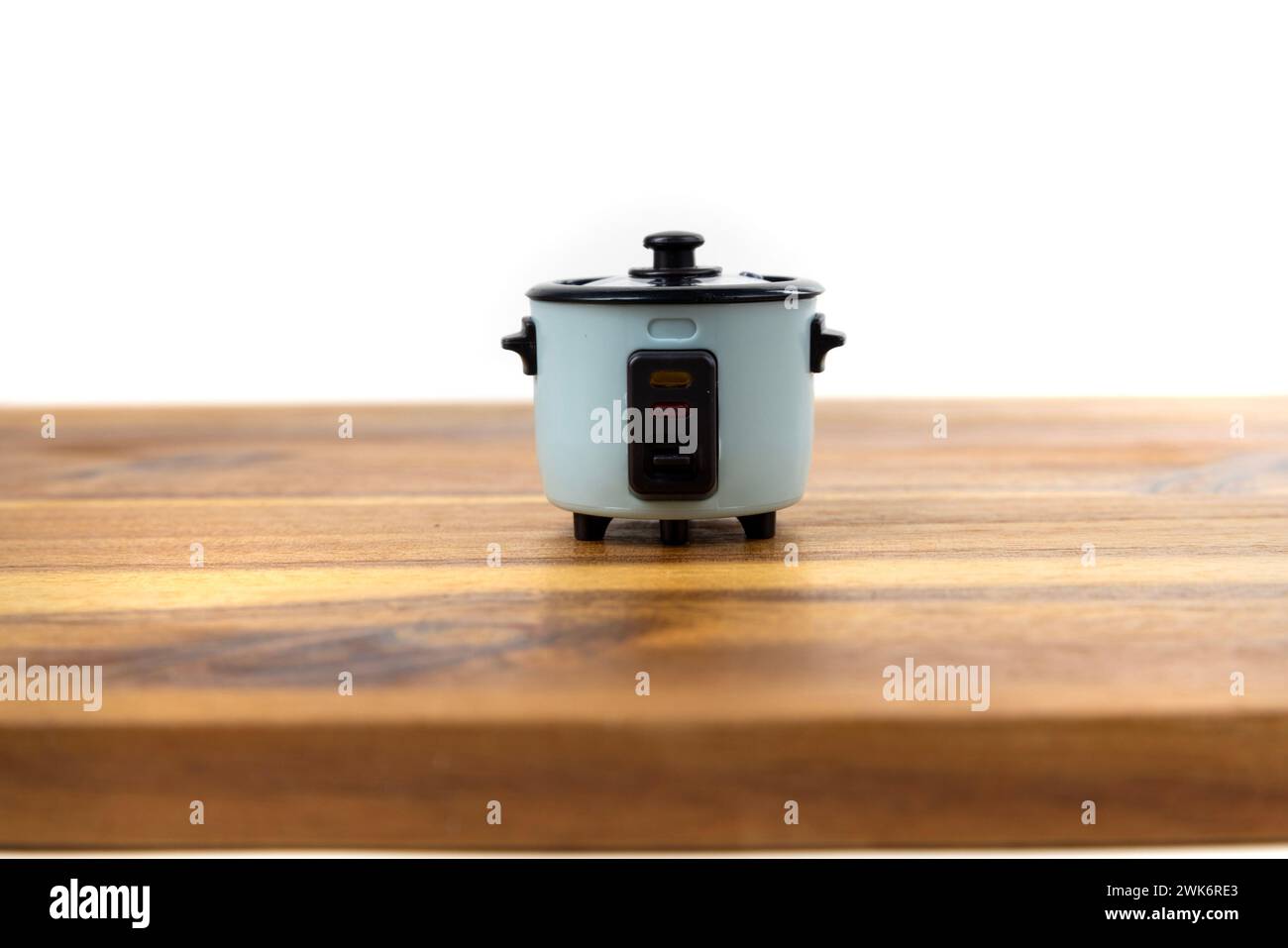 Tiny blue child's toy rice cooker on a cutting board Stock Photo - Alamy