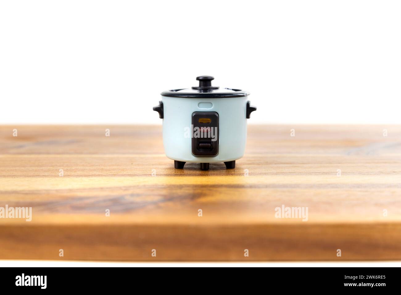 Tiny blue child's toy rice cooker on a cutting board high key Stock ...