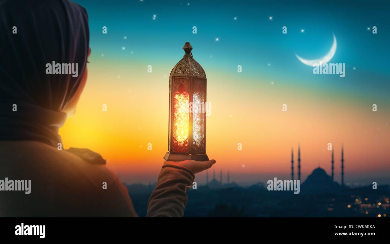 Woman is holding Ornamental Arabic lantern with burning candle glowing ...