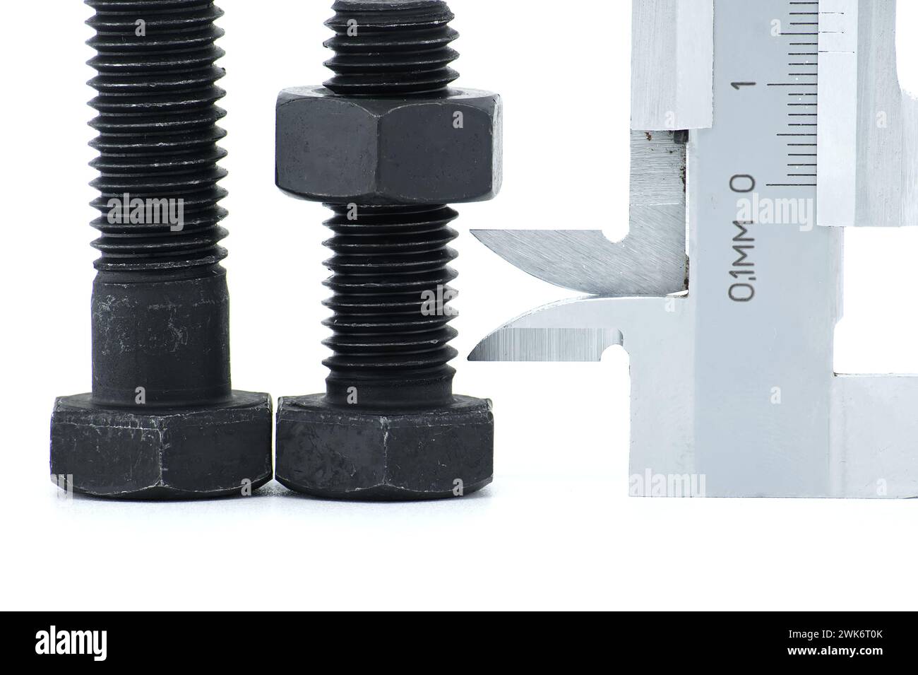 Caliper measure two adjacent black bolts with hexagonal heads, lying on ...