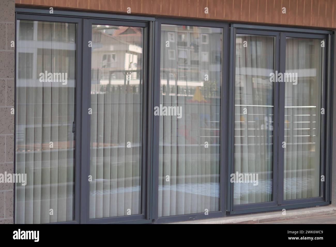 Modern front window with thin curtains and house walls from the outside ...