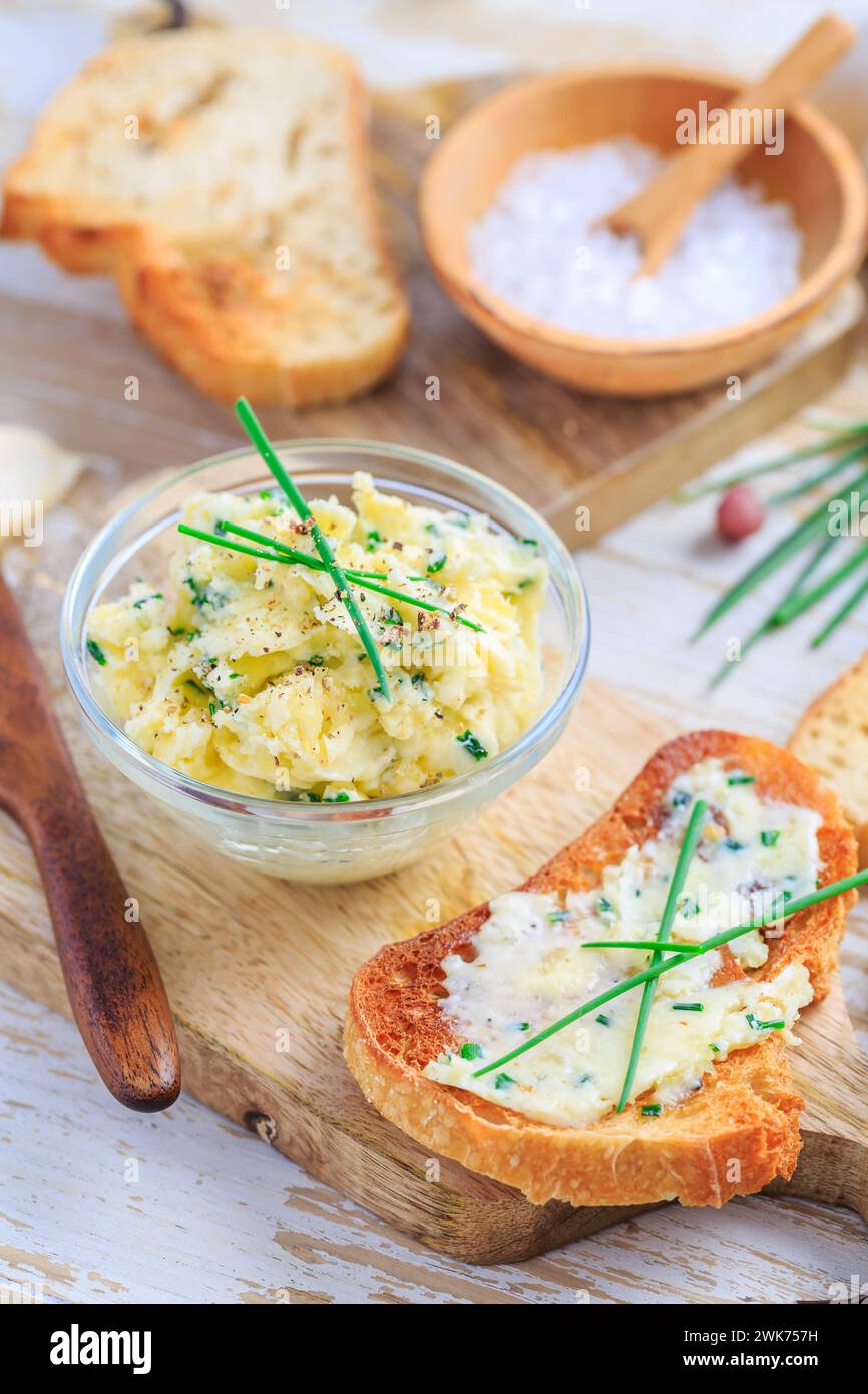Homemade garlic butter with chives and fresh roasted baguette with salt ...