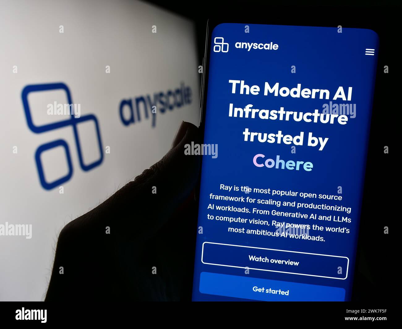 Person holding cellphone with webpage of US AI infrastructure company ...
