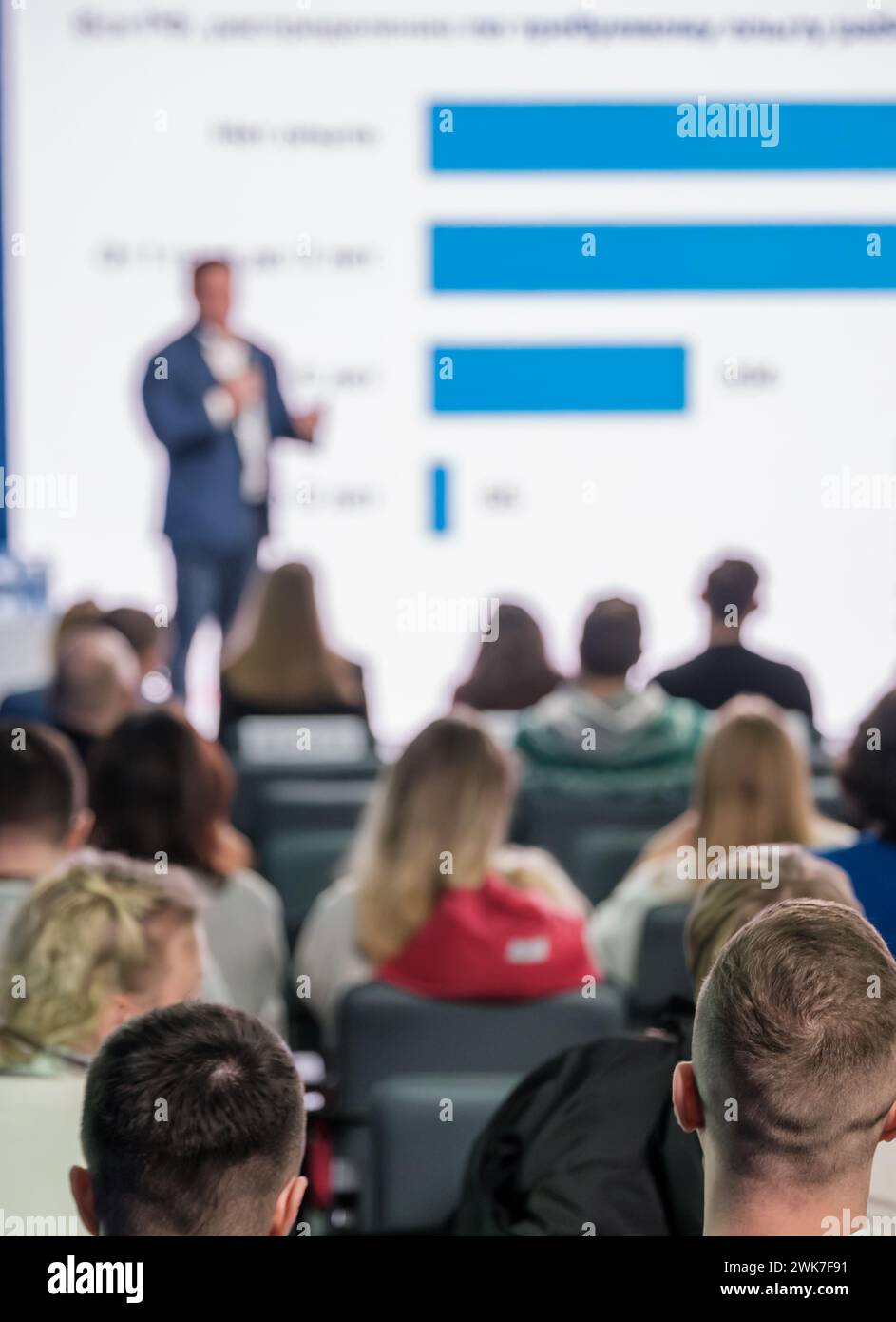 Audience attentively listening in a blurred seminar room, with ...
