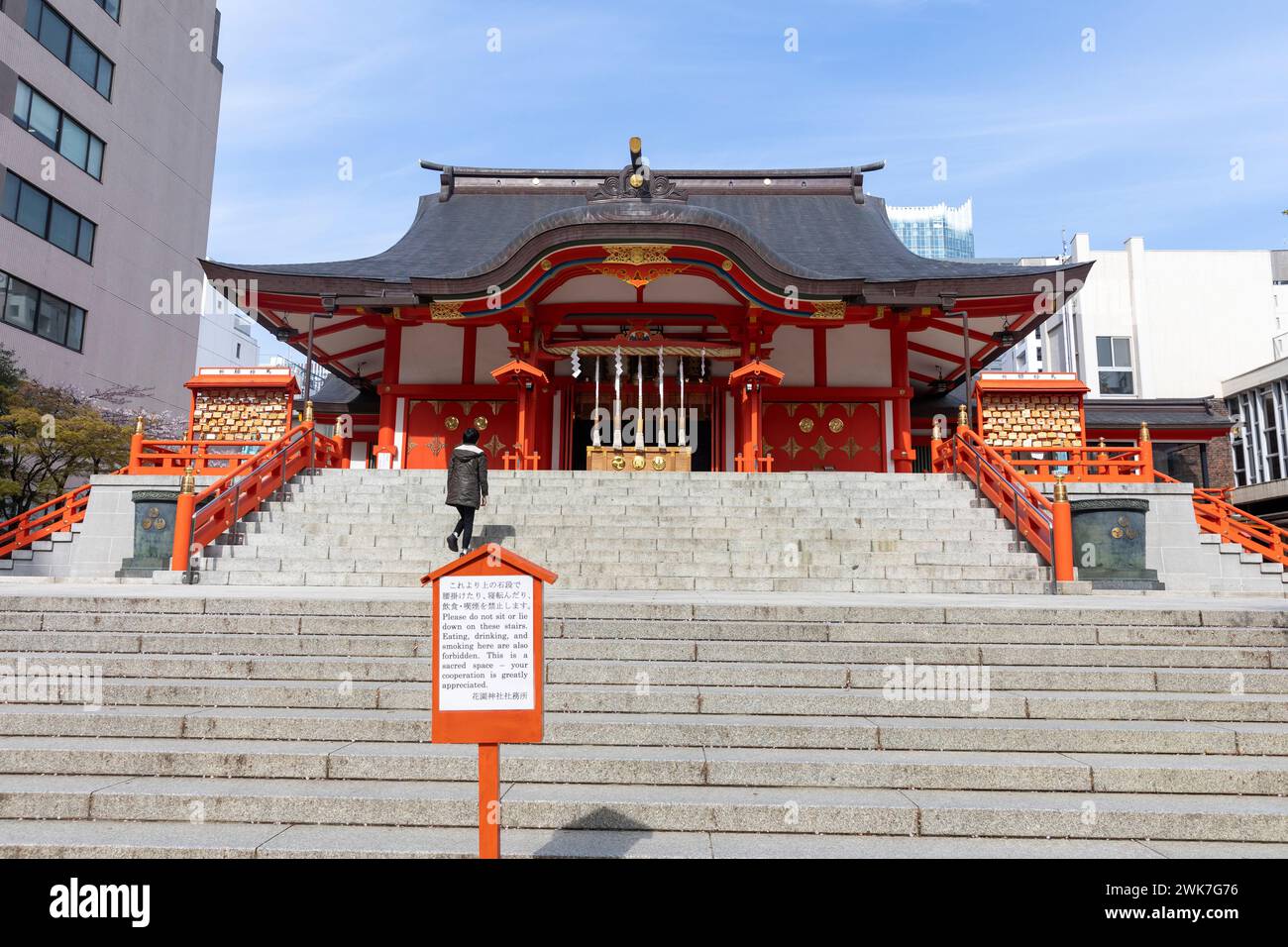 Shinjuku ward Tokyo, Hanazono shinto shrine, lady walks up the steps ...