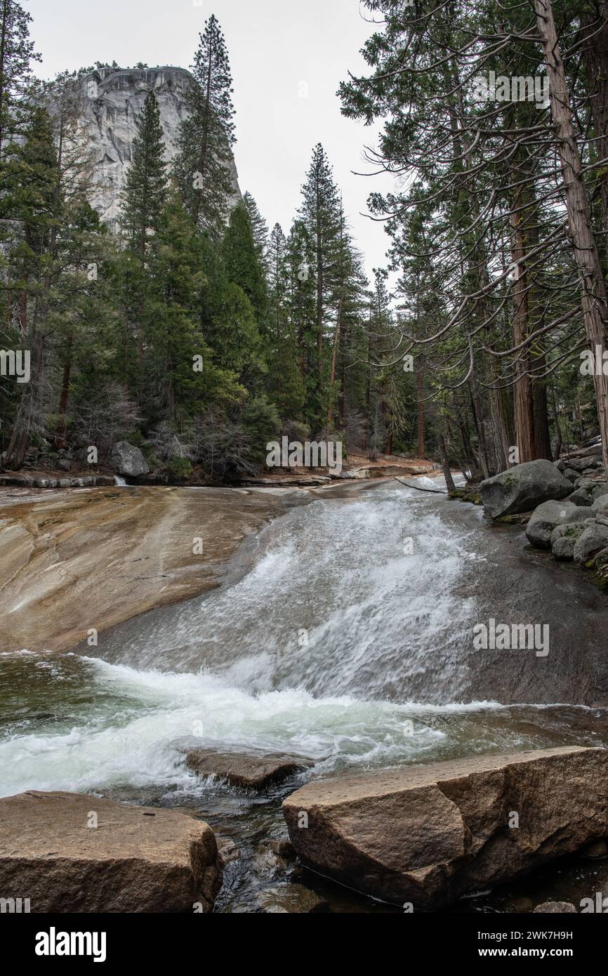 Water flowing over smooth rocks in the Merced River in the Sierra ...