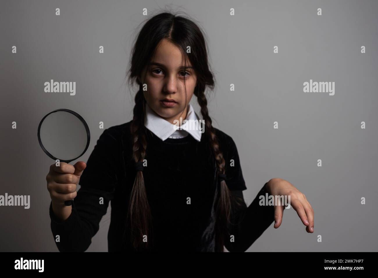 Wednesday. Gothic girl with magnifying glass Stock Photo - Alamy