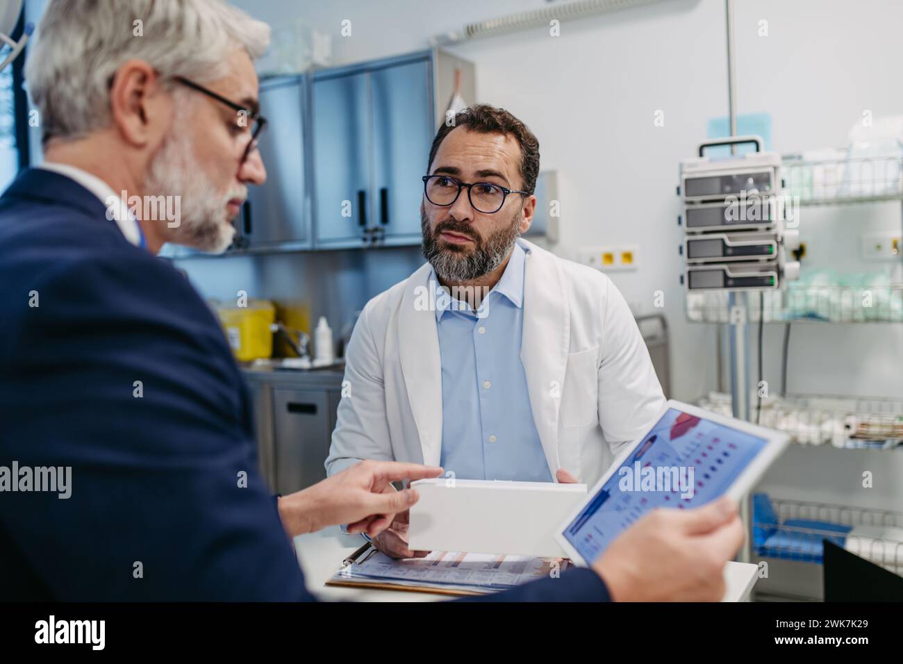 Pharmaceutical sales representative presenting new medication to doctor ...