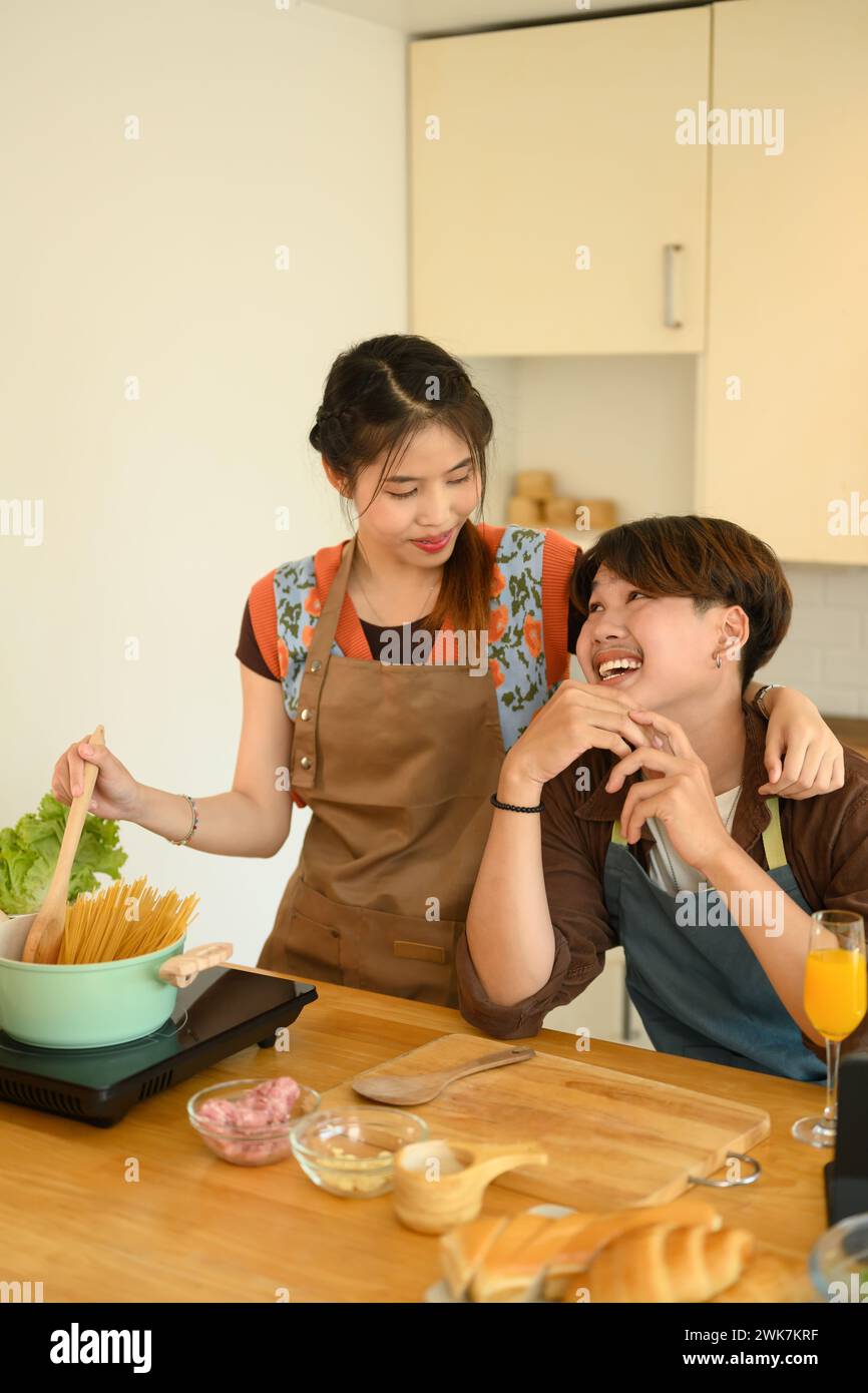 Cheerful young couple having fun cooking in the kitchen at home on ...