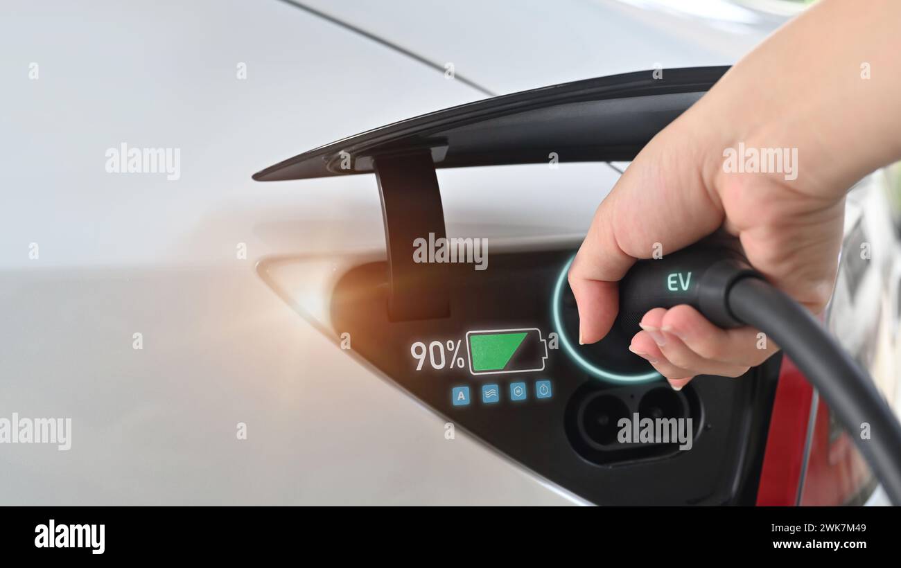 Closeup hand charging a luxury electric car with status data. Green ...