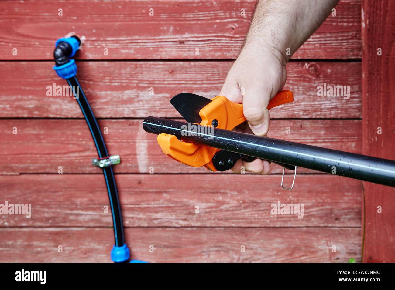 Pipe fitter cuts HDPE pipe with hand pipe cutter when installing an ...