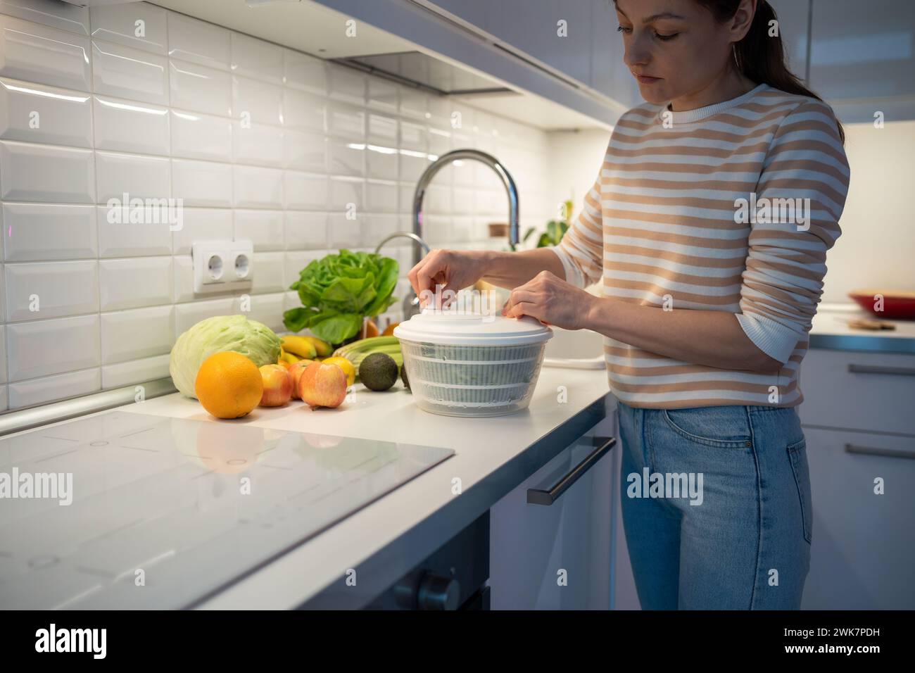 Slender female on diet cooking quick fresh healthy salad by drying ...