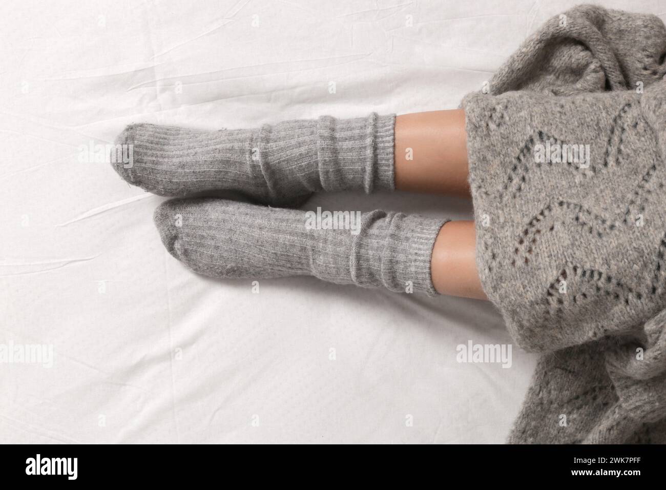 Pair of female legs wearing cozy grey cashmere socks under blanket in ...