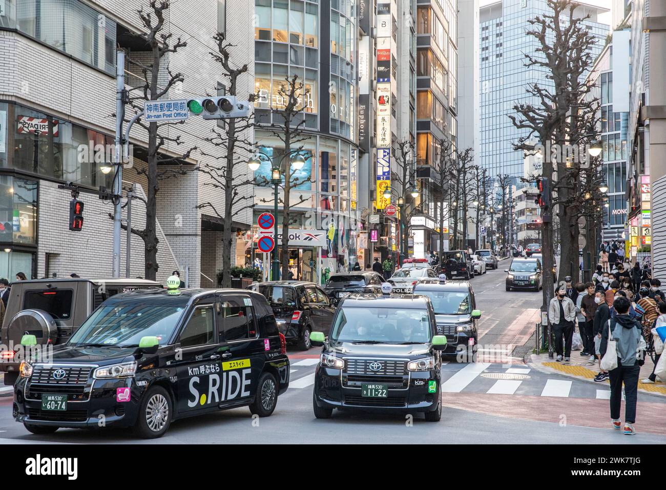 Tokyo Taxi cars vehicles in Shibuya city at dusk, shops and neon signs ...