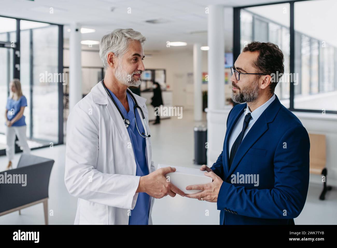 Handsome pharmaceutical sales representative presenting new medication ...