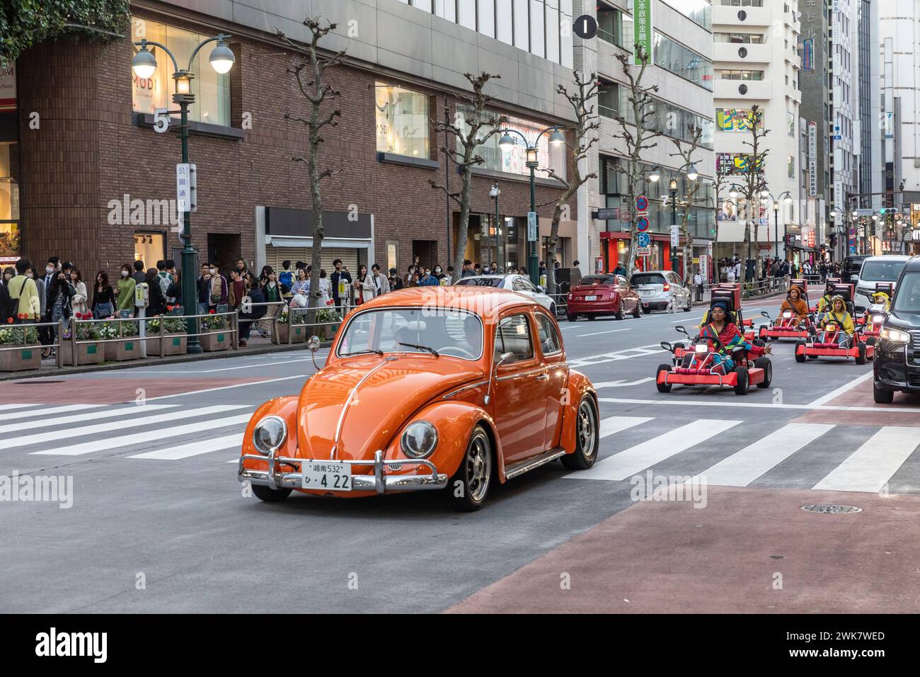 Shibuya,Tokyo, Orange VW volkswagon beetle car leads street go karts on ...