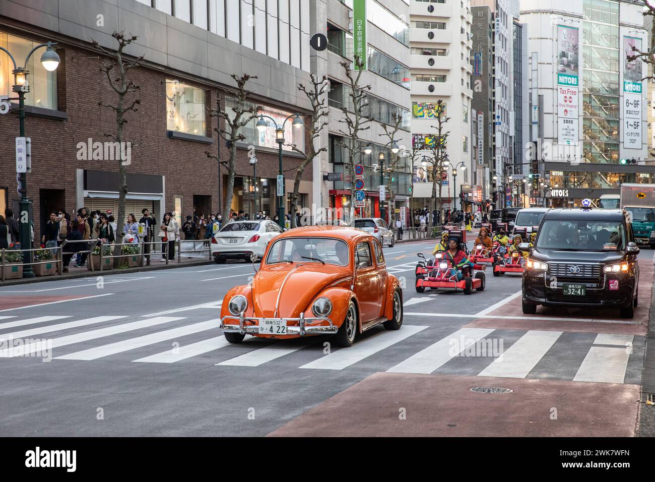 Shibuya,Tokyo, Orange VW volkswagon beetle car leads street go karts on ...