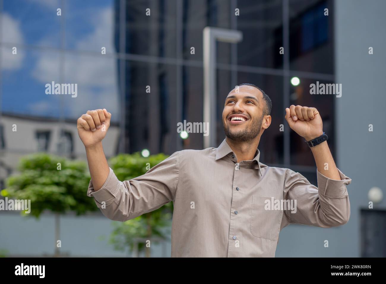 Happy hispanic young man dancing near office center and courthouse ...