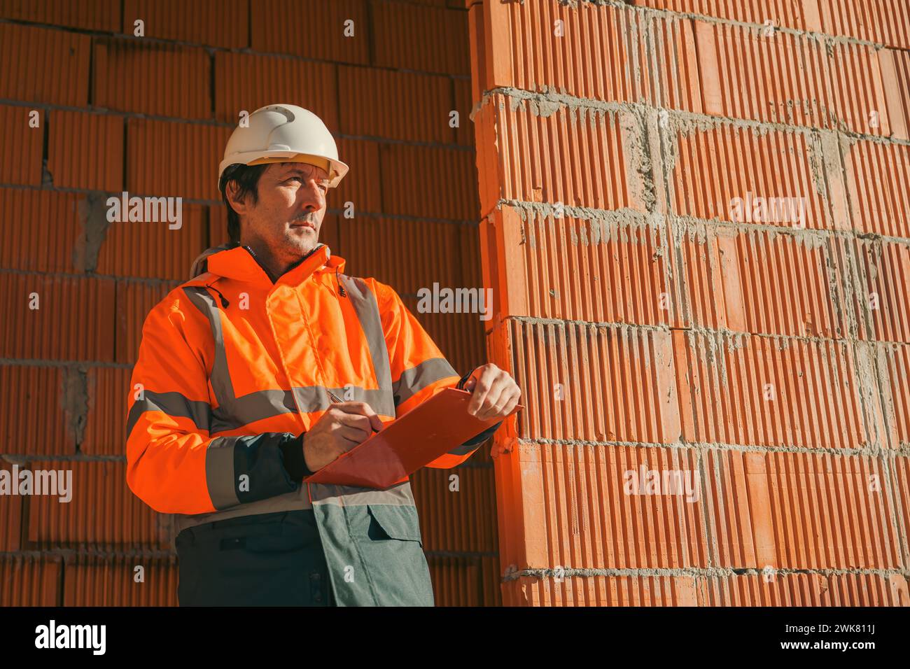 Architect and construction engineer making notes and remarks during ...