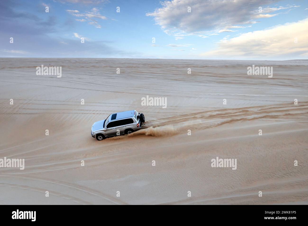 A Toyota Land Cruiser climbing up the desert mountain in Sealine Sand ...