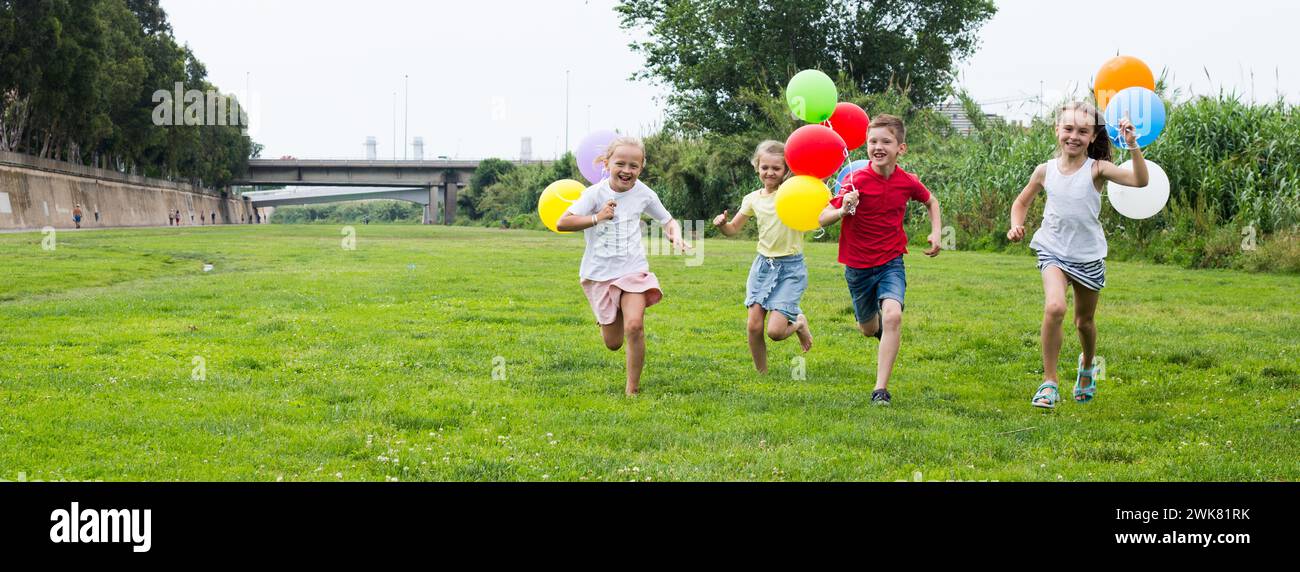 Children with balloons run in the summer park Stock Photo - Alamy