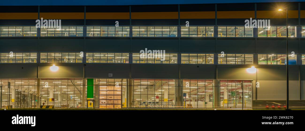 Warehouse facade at night, view of the illuminated warehouse through ...
