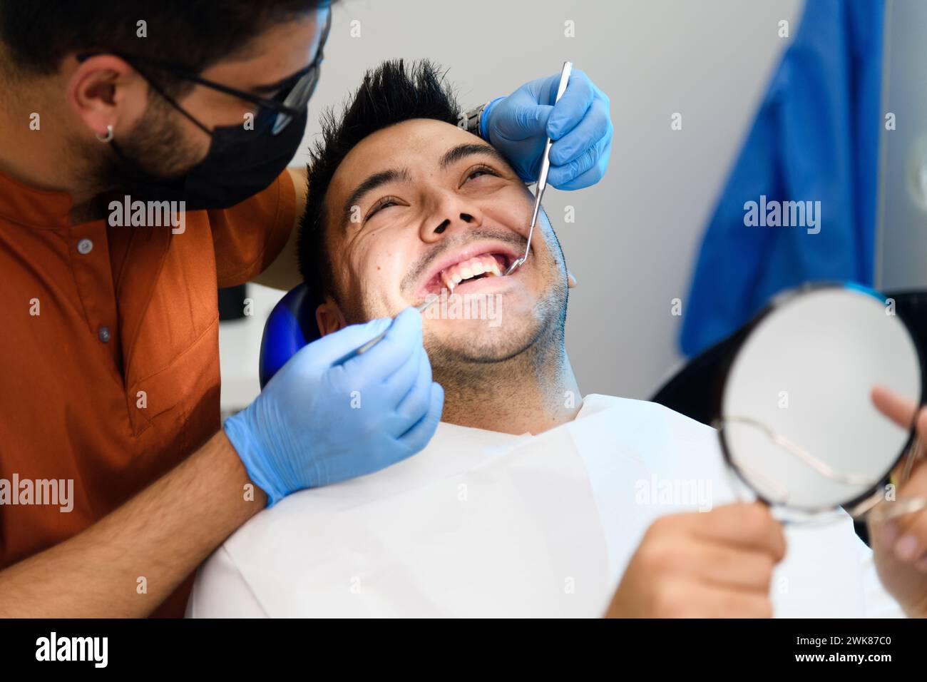 A patient shares a joyful moment with his dentist during an examination ...