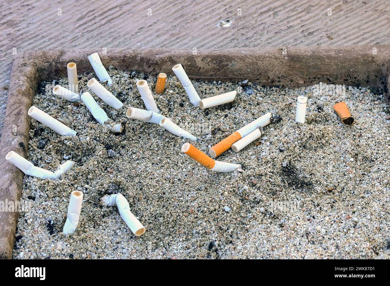 Cigarette stubs in a tray outside a restaurant Stock Photo - Alamy