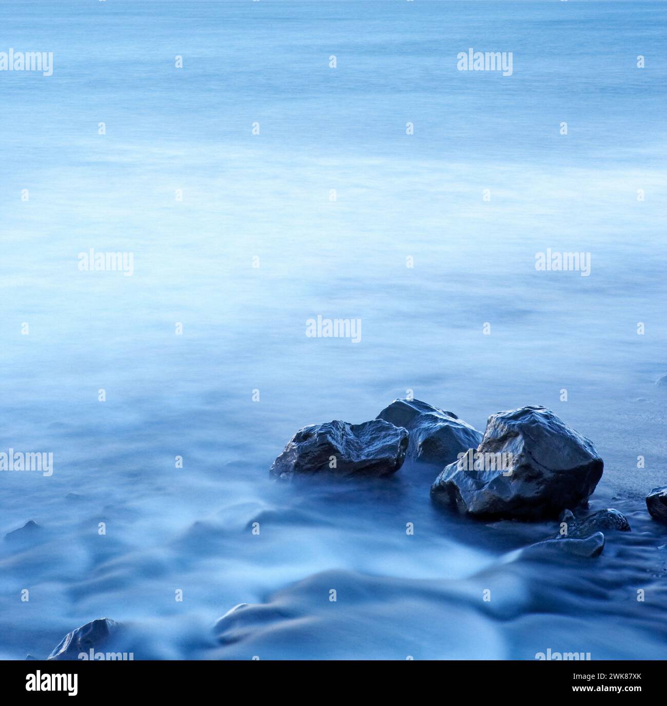 Blurred water around wet stone Stock Photo - Alamy