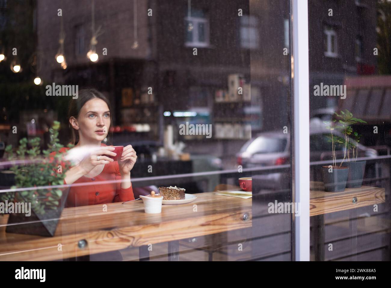 Outside View of Cafe With a Young Woman Sitting Inside By Window Stock ...