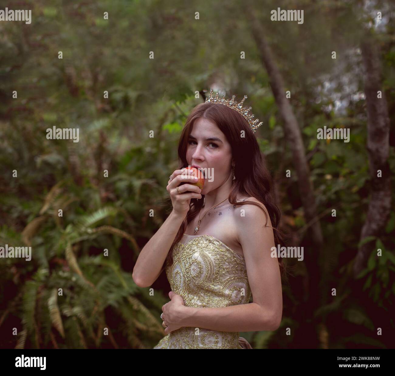 Princess in forest biting into apple Stock Photo - Alamy
