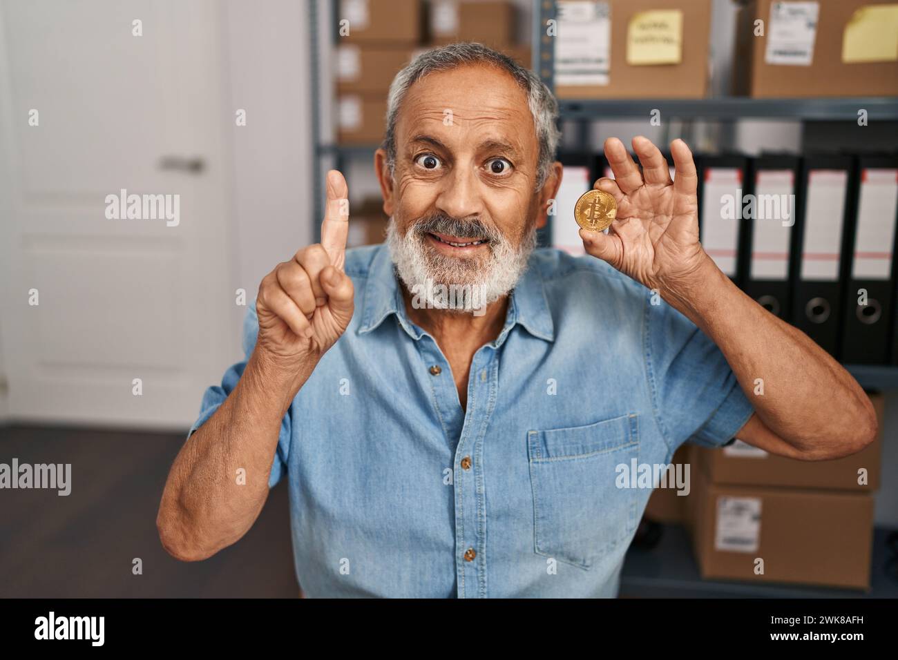 Cheerful senior man at office, confidently pointing finger with ...