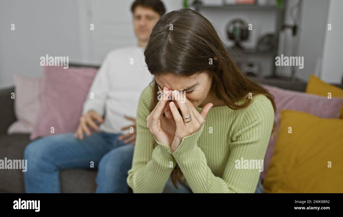 A distressed woman with hand on forehead sits in front of a concerned ...