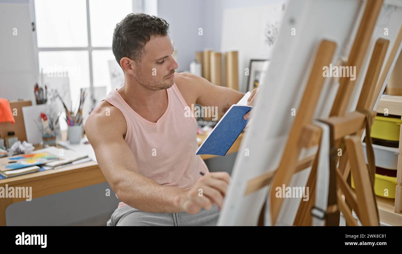 A focused man painting on canvas in a bright art studio, showcasing ...